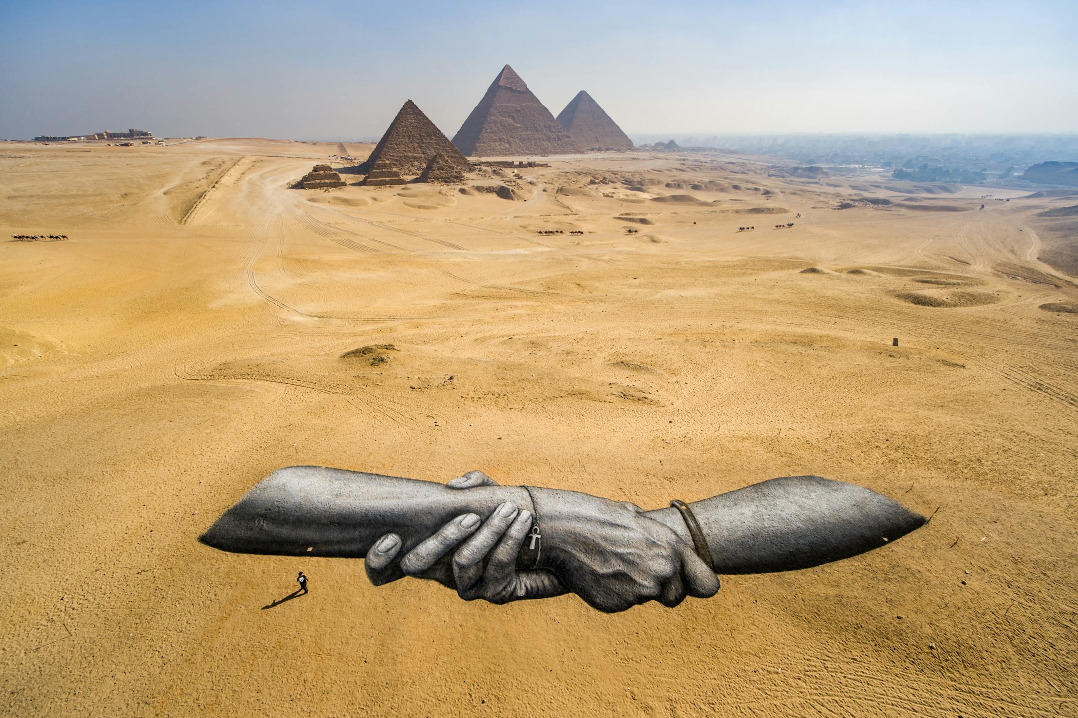 International artist Saype paints gigantic hands in Minneapolis' Boom ...